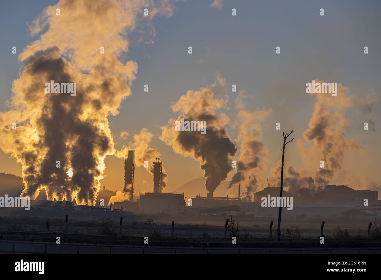 Factory smoke chimneys piping smoke or steam into the air, producing ...