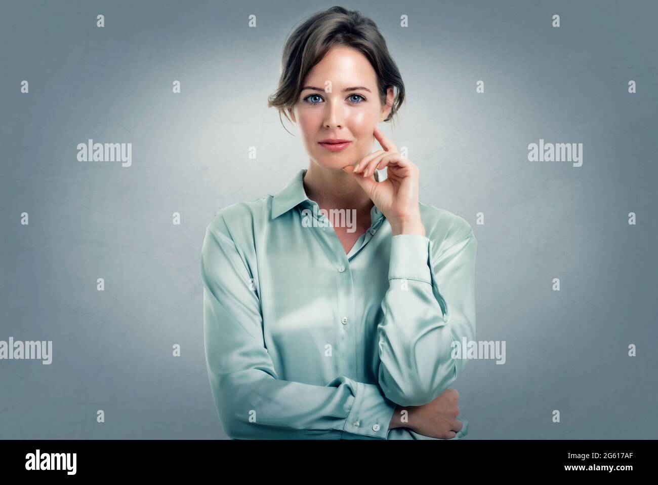 Studio portrait of thinking business woman standing isolated light grey ...