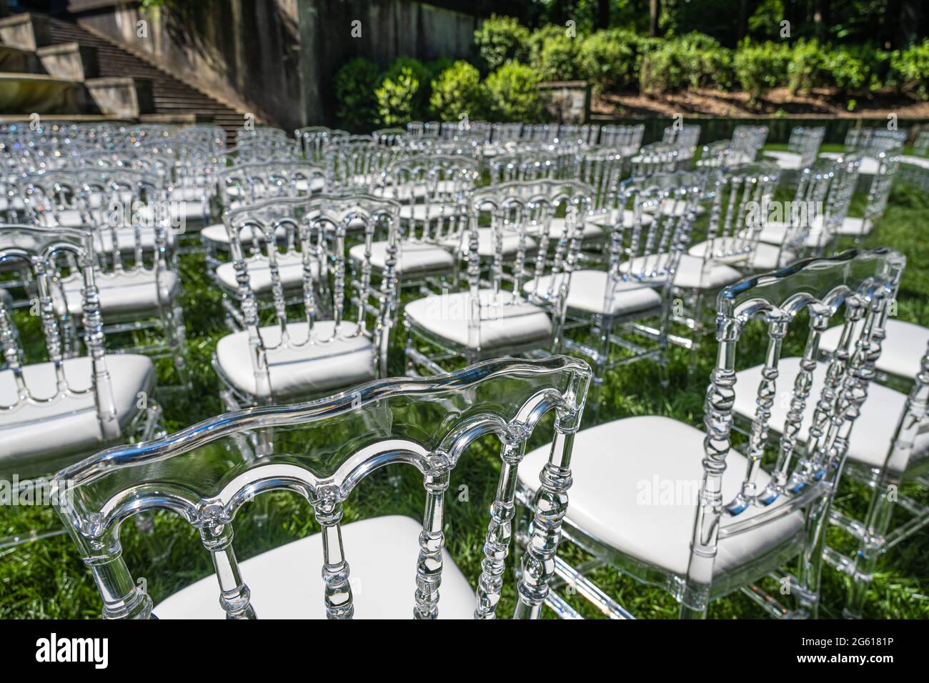 Wedding event seating glistens in the sun on the terraced lawn below ...