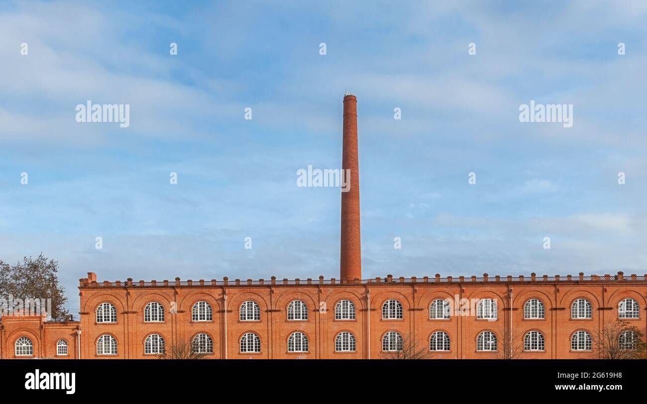 Old factory in orange brick with giant chimney Stock Photo - Alamy