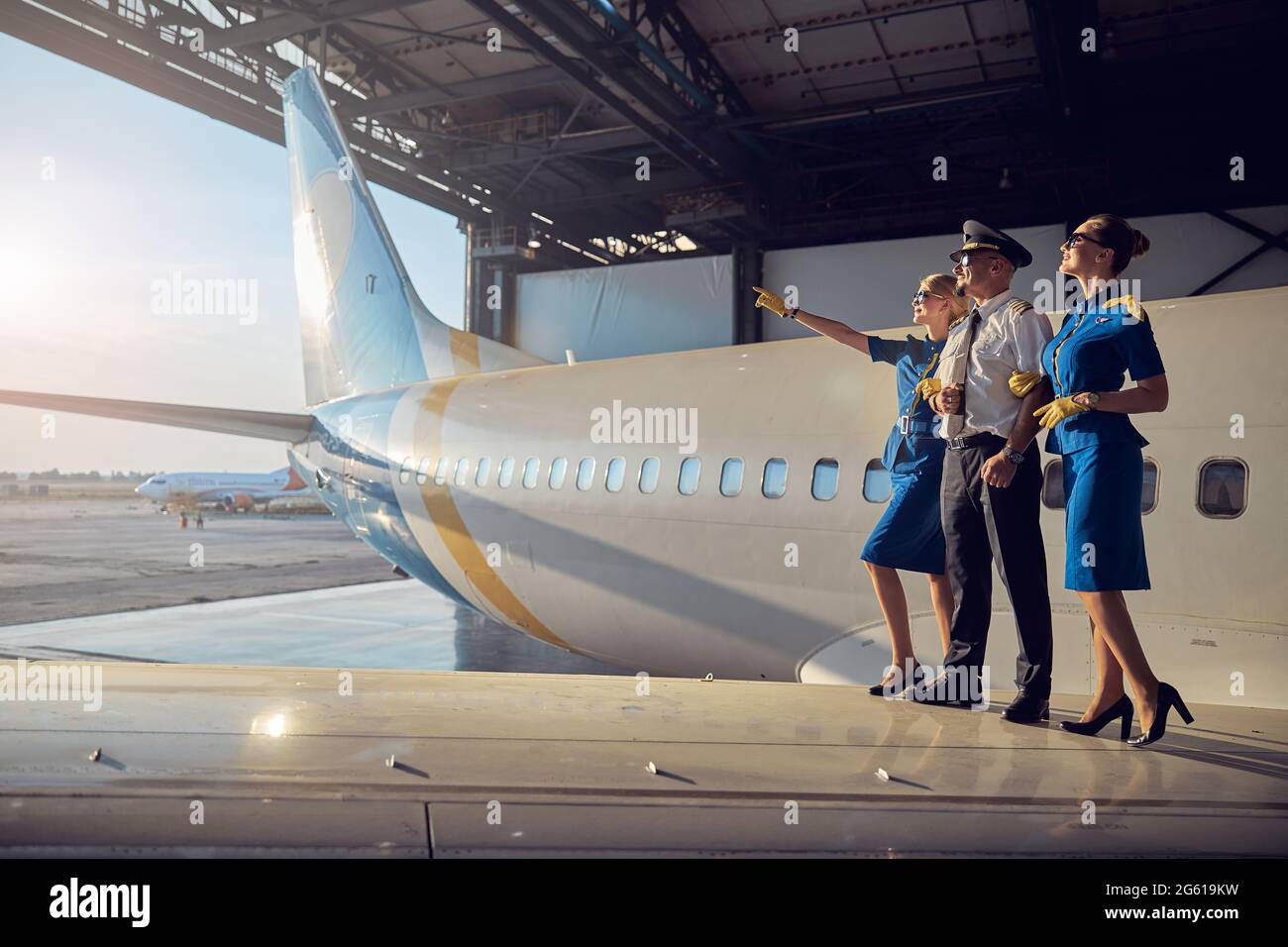 Pilot with two beautiful women flight attendant in front of aircraft ...