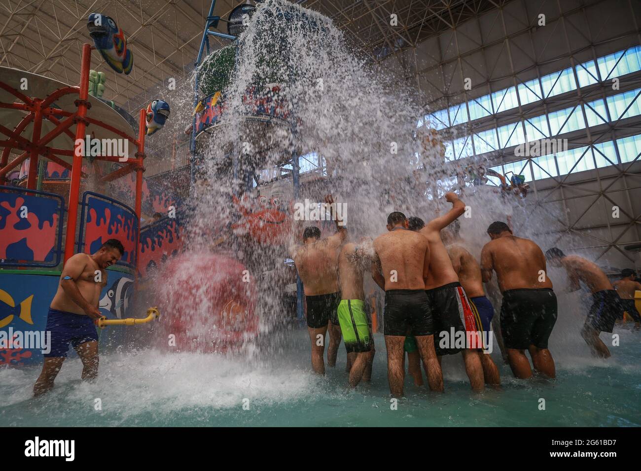 Baghdad, Iraq. 01st July, 2021. Iraqis cool off under showers of water ...