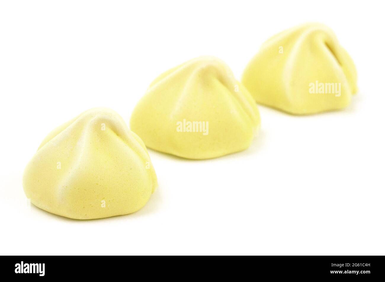 A Line of Three Yellow Meringues on a White Background Stock Photo - Alamy