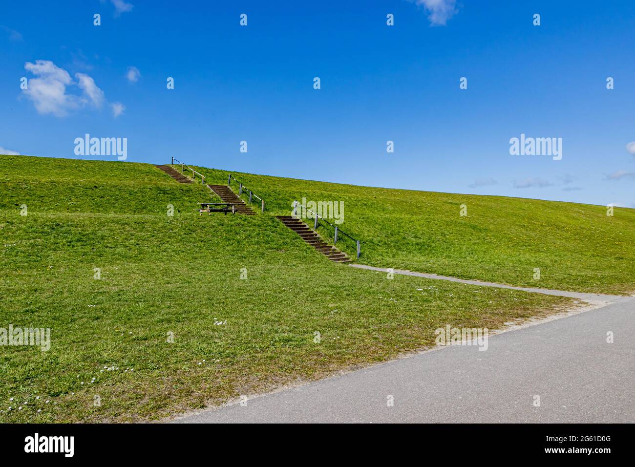 Dike on the beach of Camperduin with green grass and concrete stairs ...