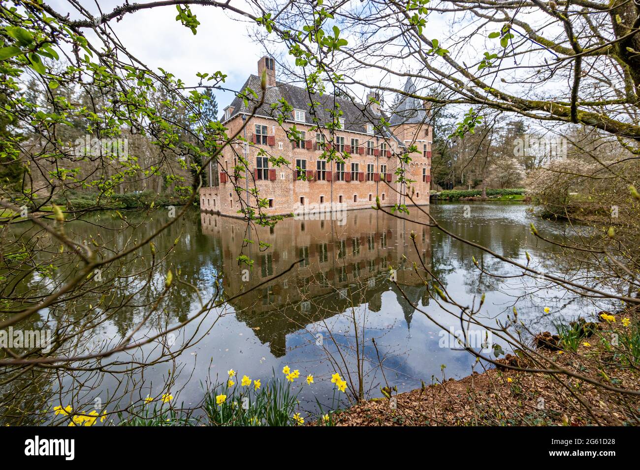 Het Oude Loo castle with its moat with reflection in the water and its ...