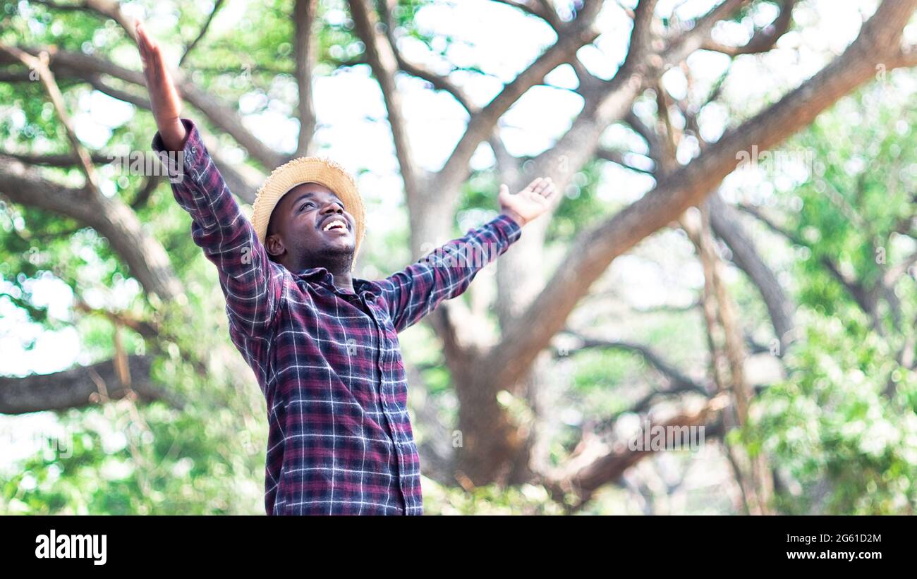 Freedom african man is wearing hat standing with the green nature ...