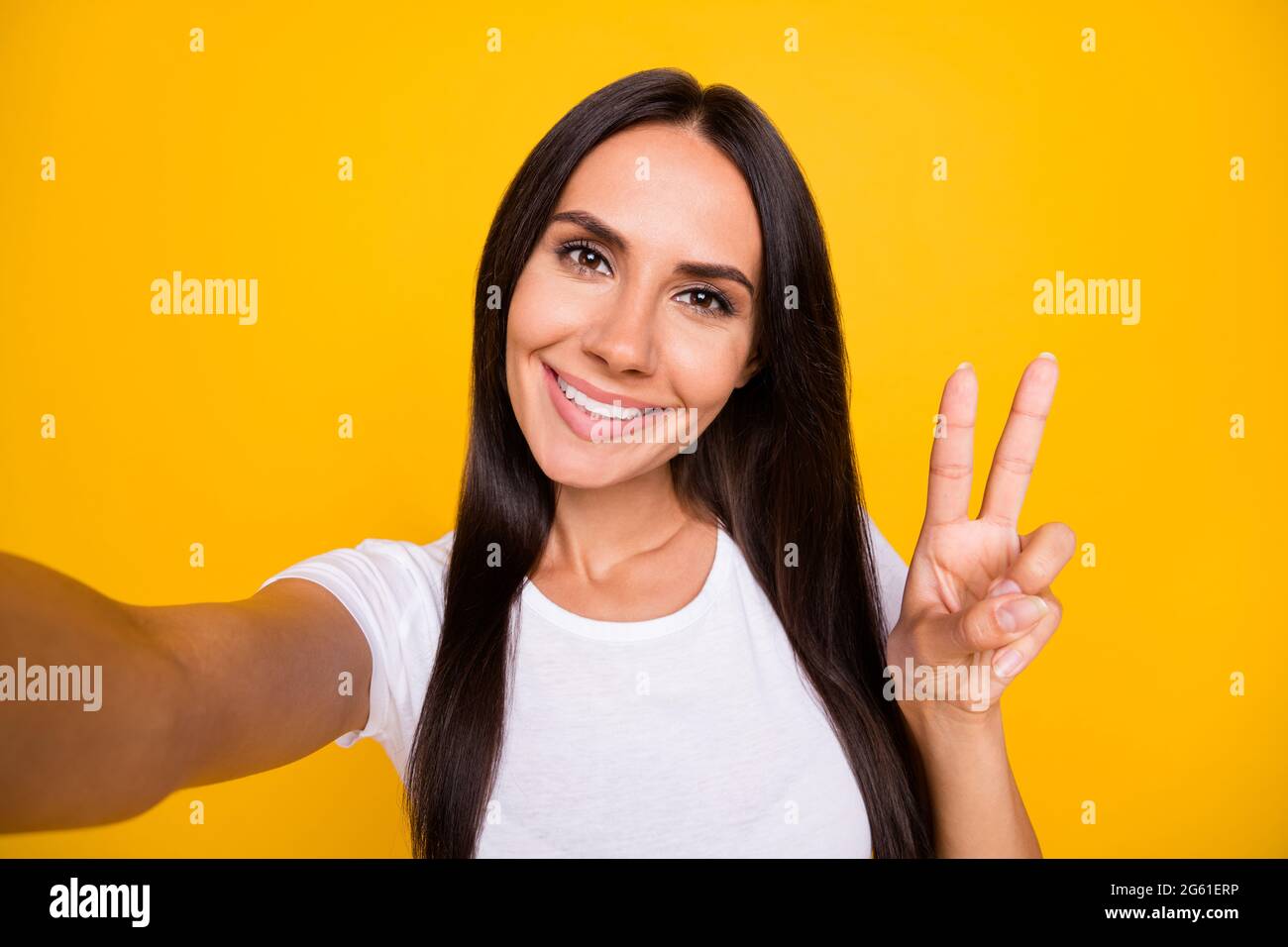 Photo portrait of brunette blogger taking selfie smiling showing v-sign ...