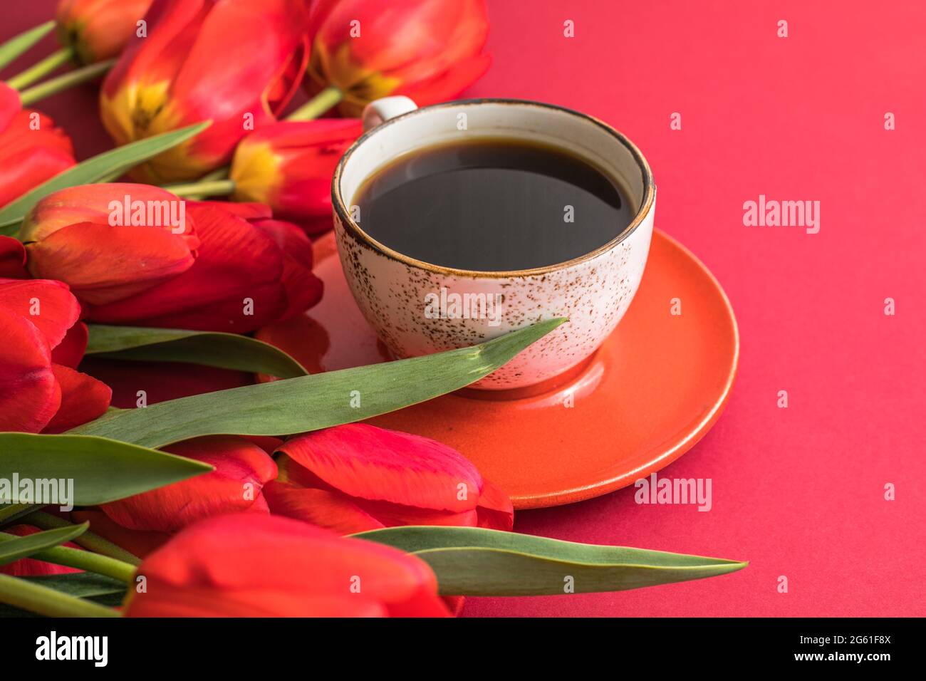 Bouquet of red tulips and coffee cup arrangement with a lot of copy ...