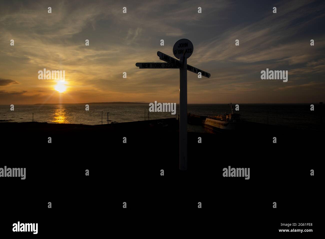 The sun setting behind the iconic signpost at John O'Groats in the ...