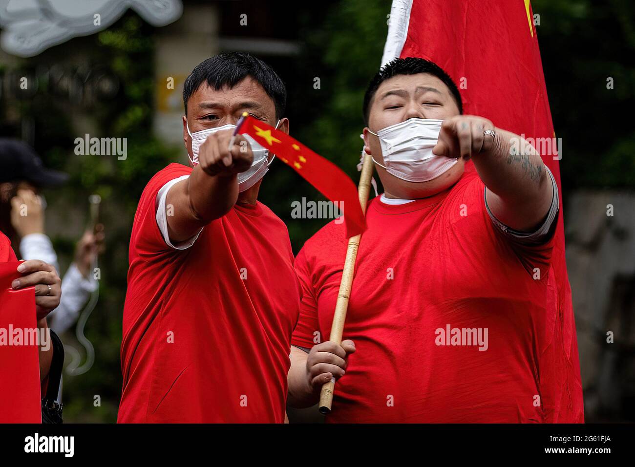 Pro-Beijing supporters with Chinese flags pointing at their counter ...