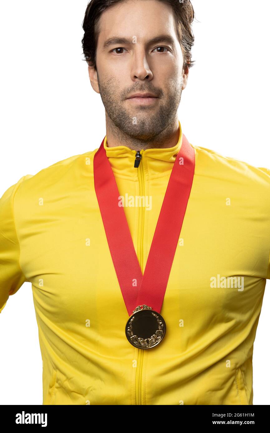 male athlete smiling after winning a gold medal in a white background ...