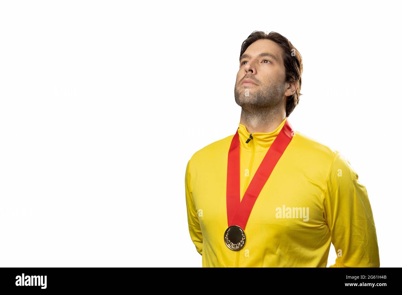 male athlete smiling after winning a gold medal in a white background ...