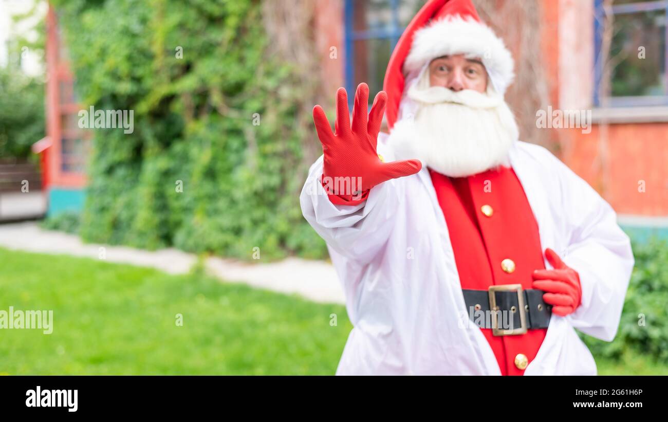 Santa claus in a protective suit shows a stop gesture with his palm ...
