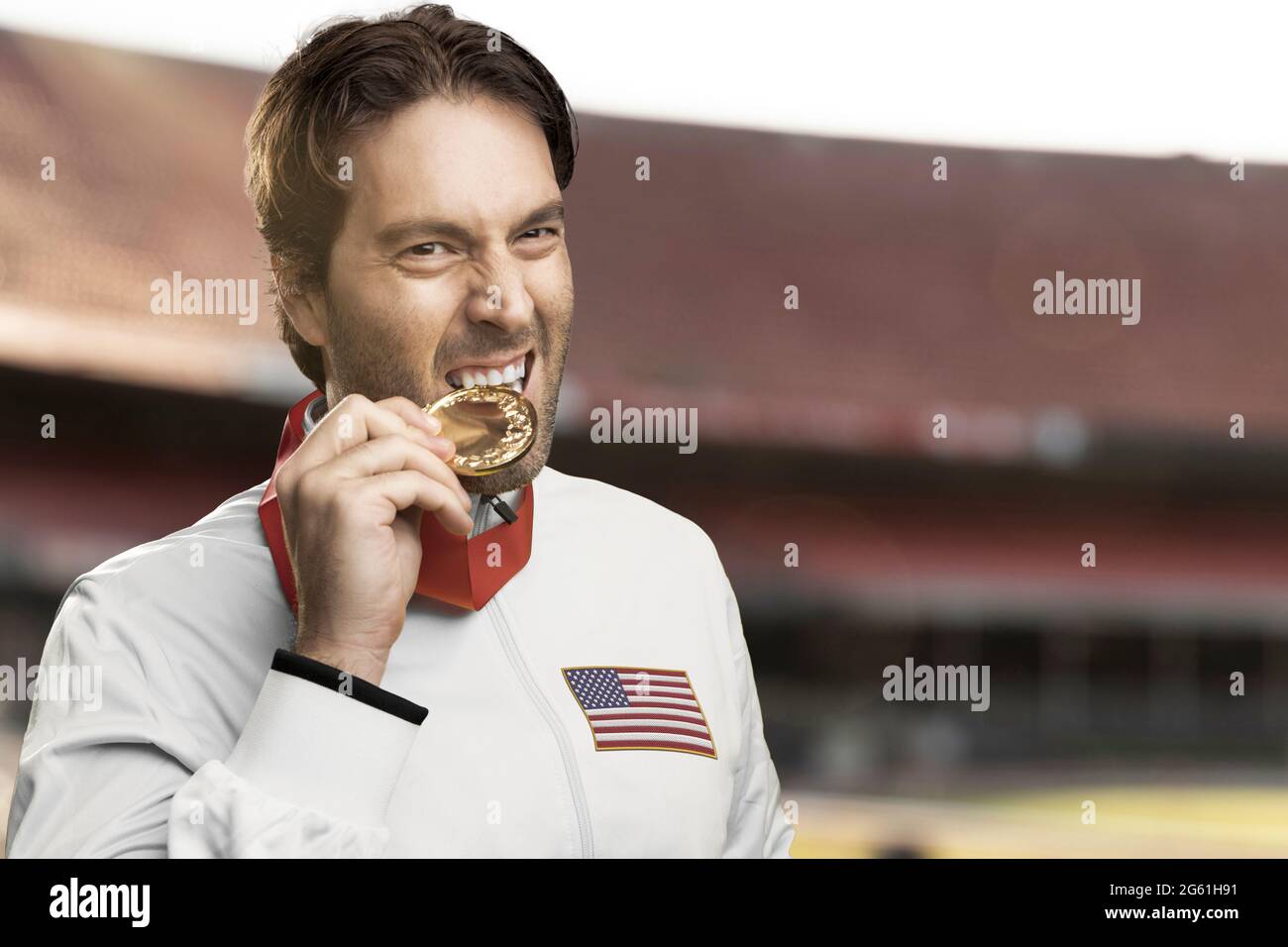 American male athlete smiling after winning a gold medal in a stadium ...