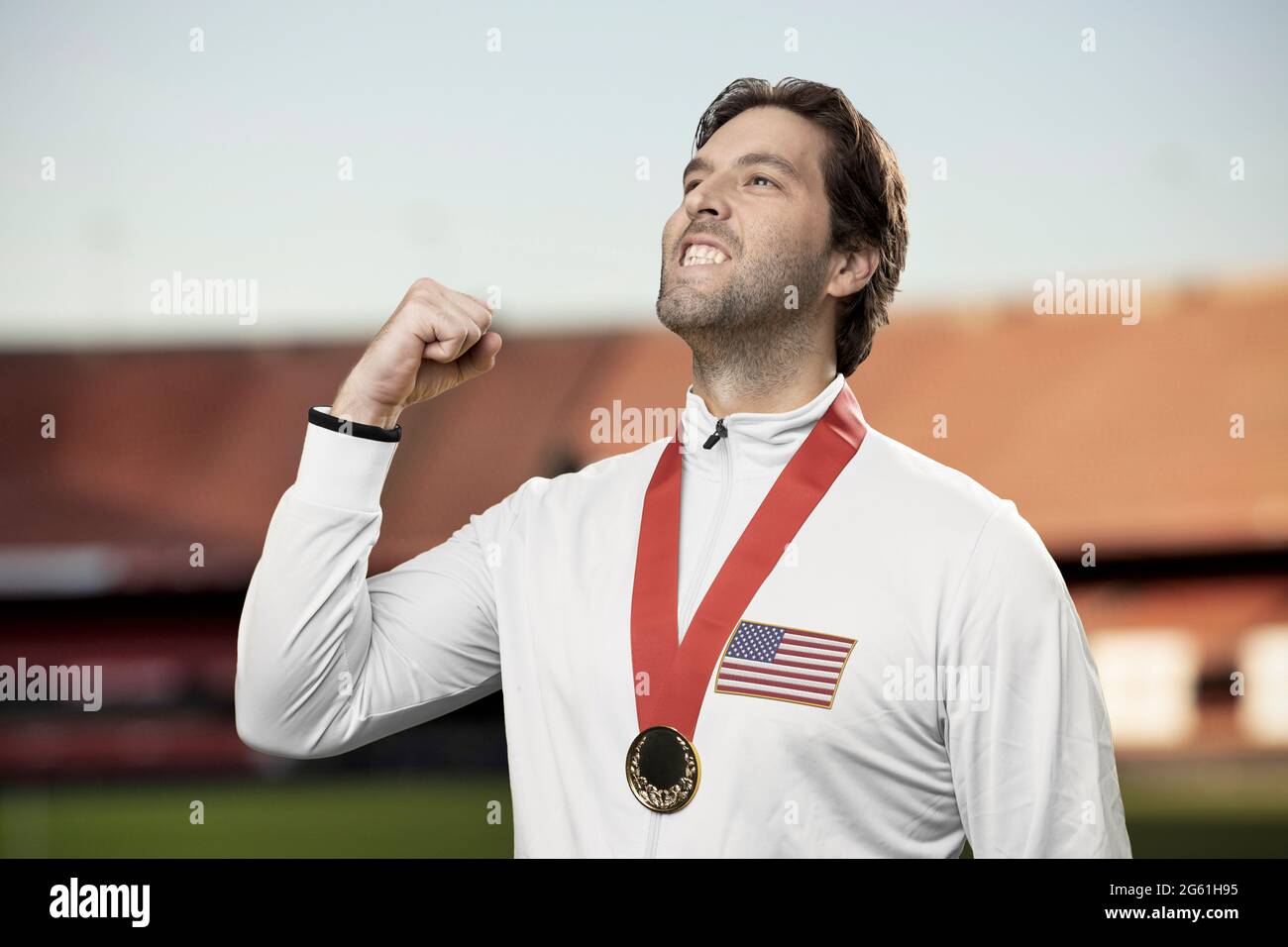 American male athlete smiling after winning a gold medal in a stadium ...