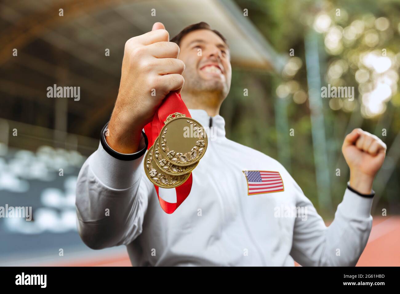 American male athlete smiling after winning a gold medal in a stadium ...