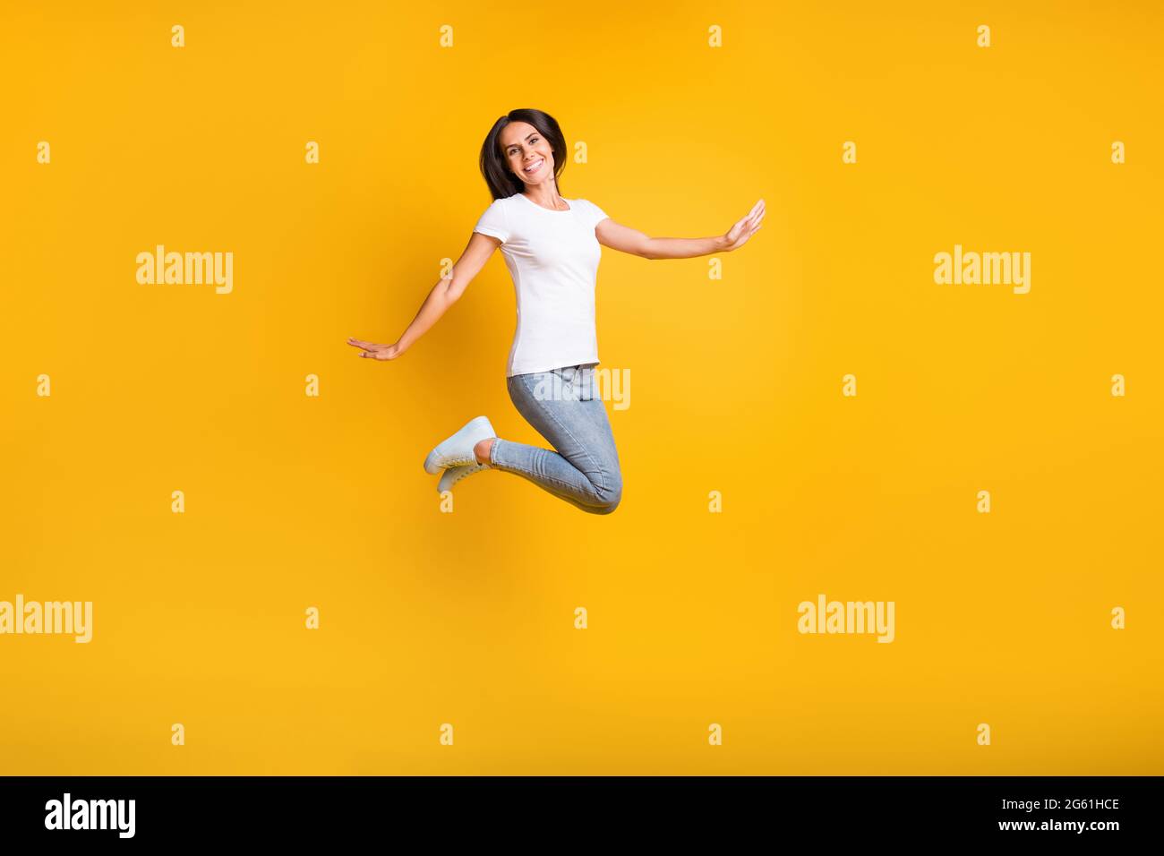 Full length photo of charming pretty young woman jump ups air raise ...