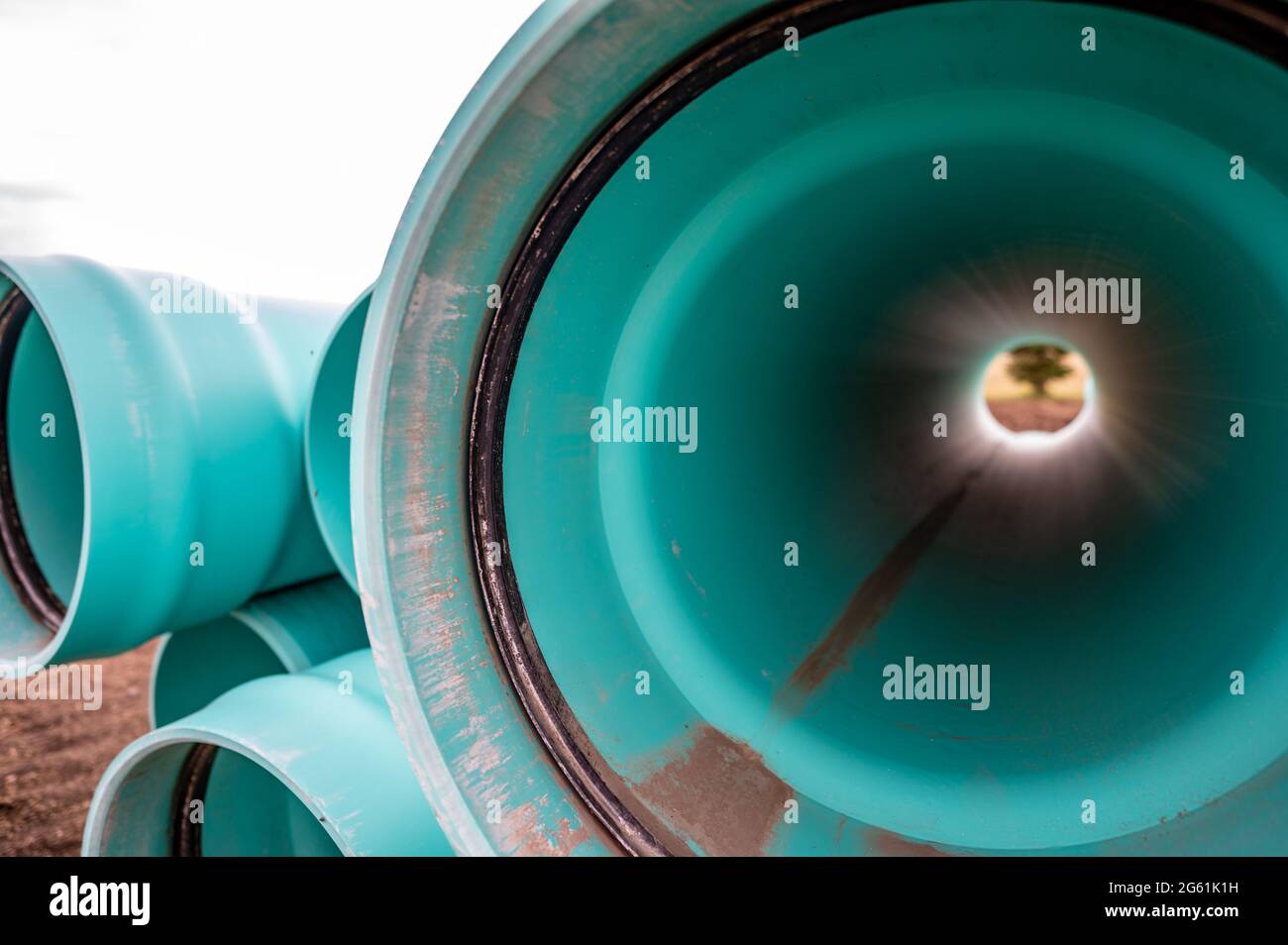 Stacked water main pipe with bell fitting next to an exposed trench for ...