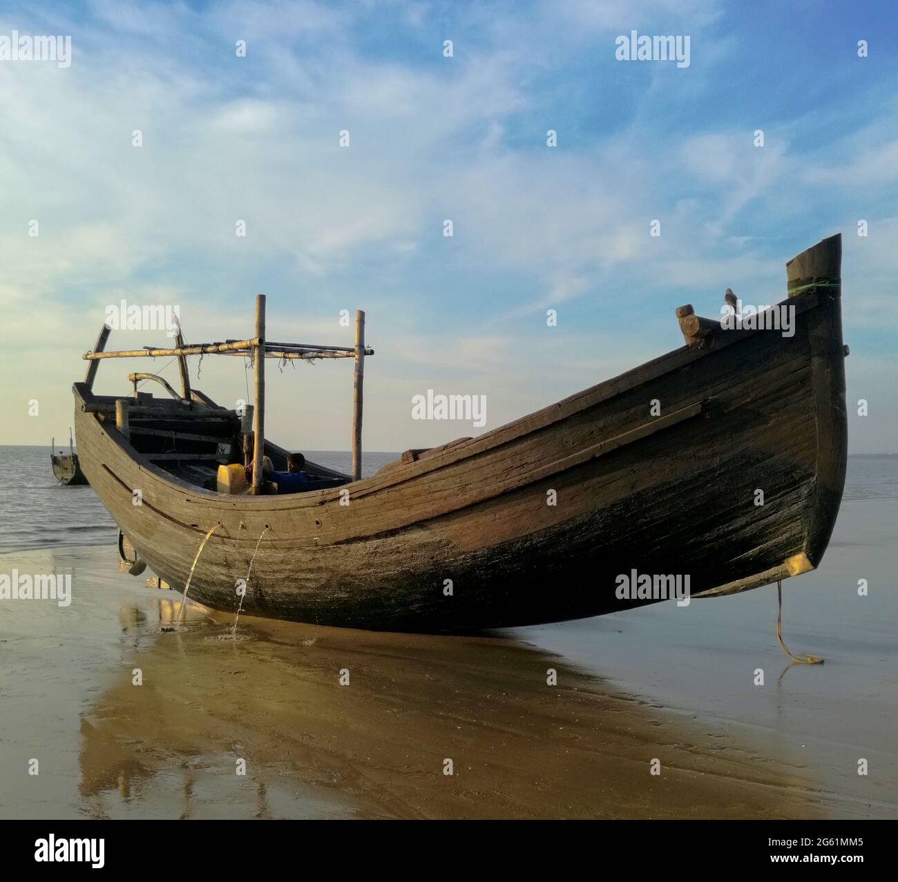 Vertical shot of an empty wooden boat on a sandy shore Stock Photo - Alamy
