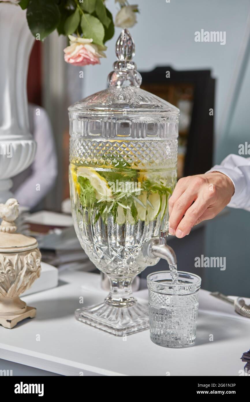 Catering Waiter pours non-alcoholic lemonade to meet guests at a ...