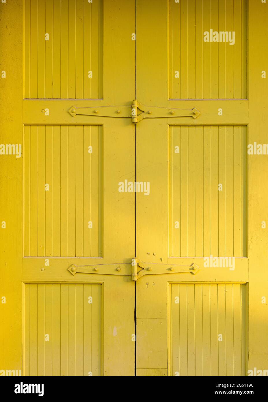 Closed wooden yellow doors with yellow hinges Stock Photo - Alamy