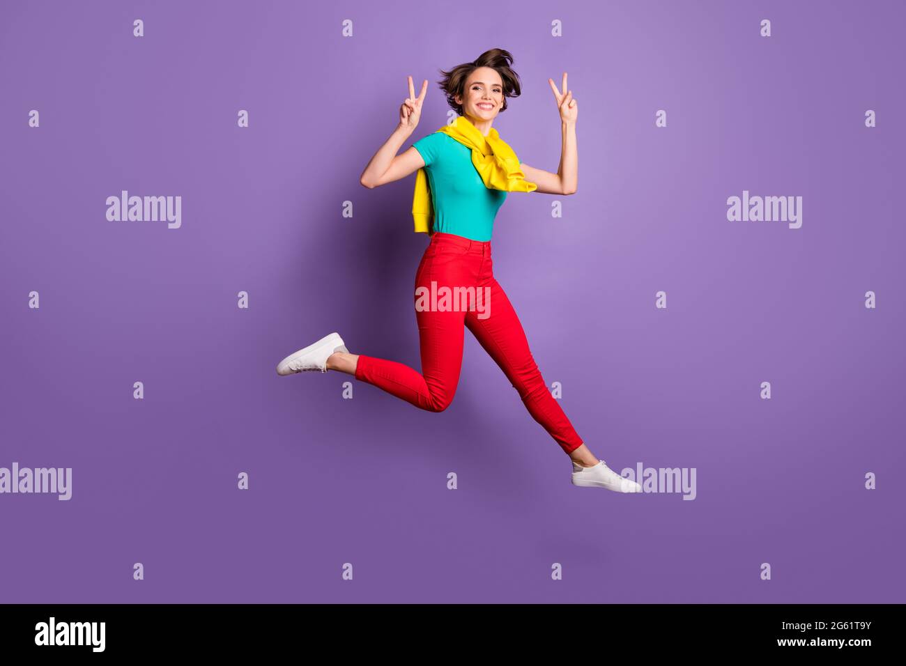 Full length photo of girl jump show v-sign wear tied sweater t-shirt ...