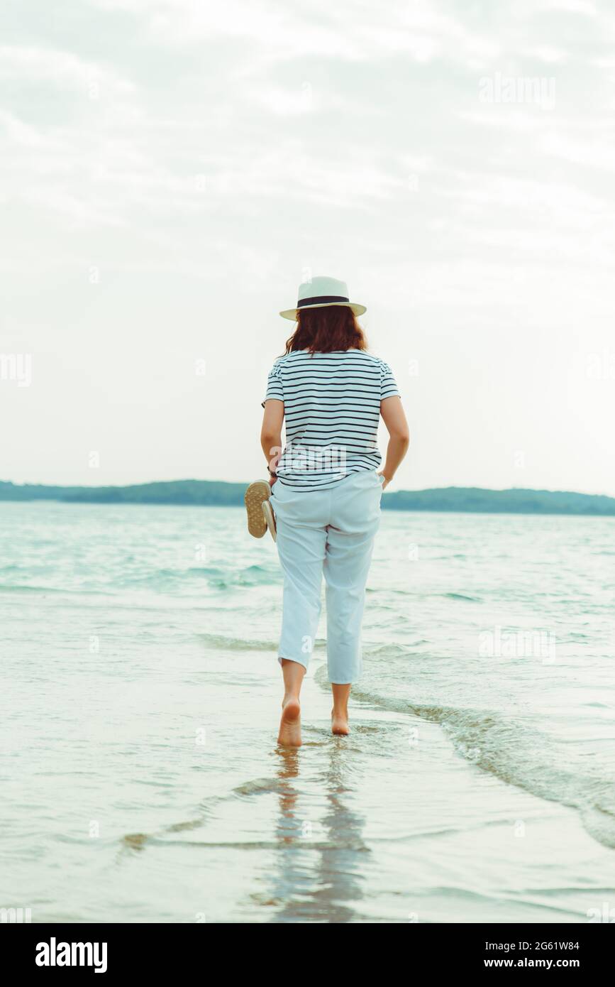 woman in white clothes walking by sea beach summer time Stock Photo - Alamy