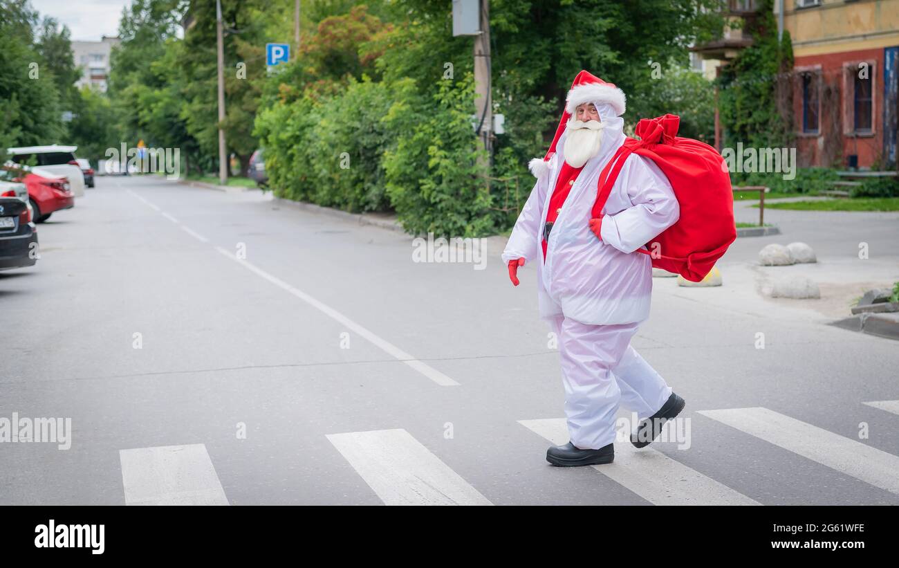 Santa Claus wearing in a protective suit walking the road at a ...