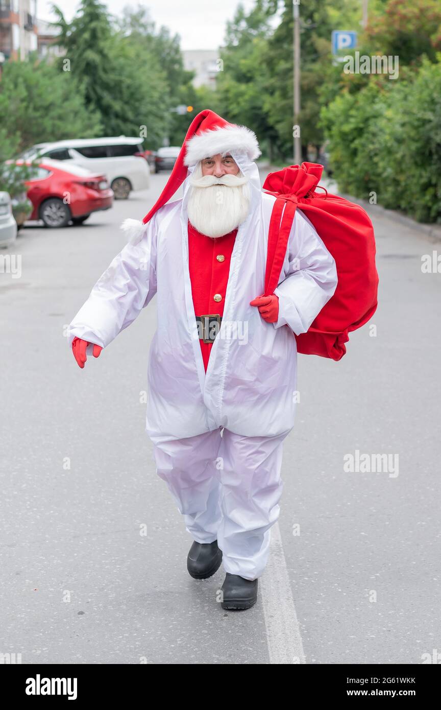 Santa Claus wearing in a protective suit walking the road at a ...