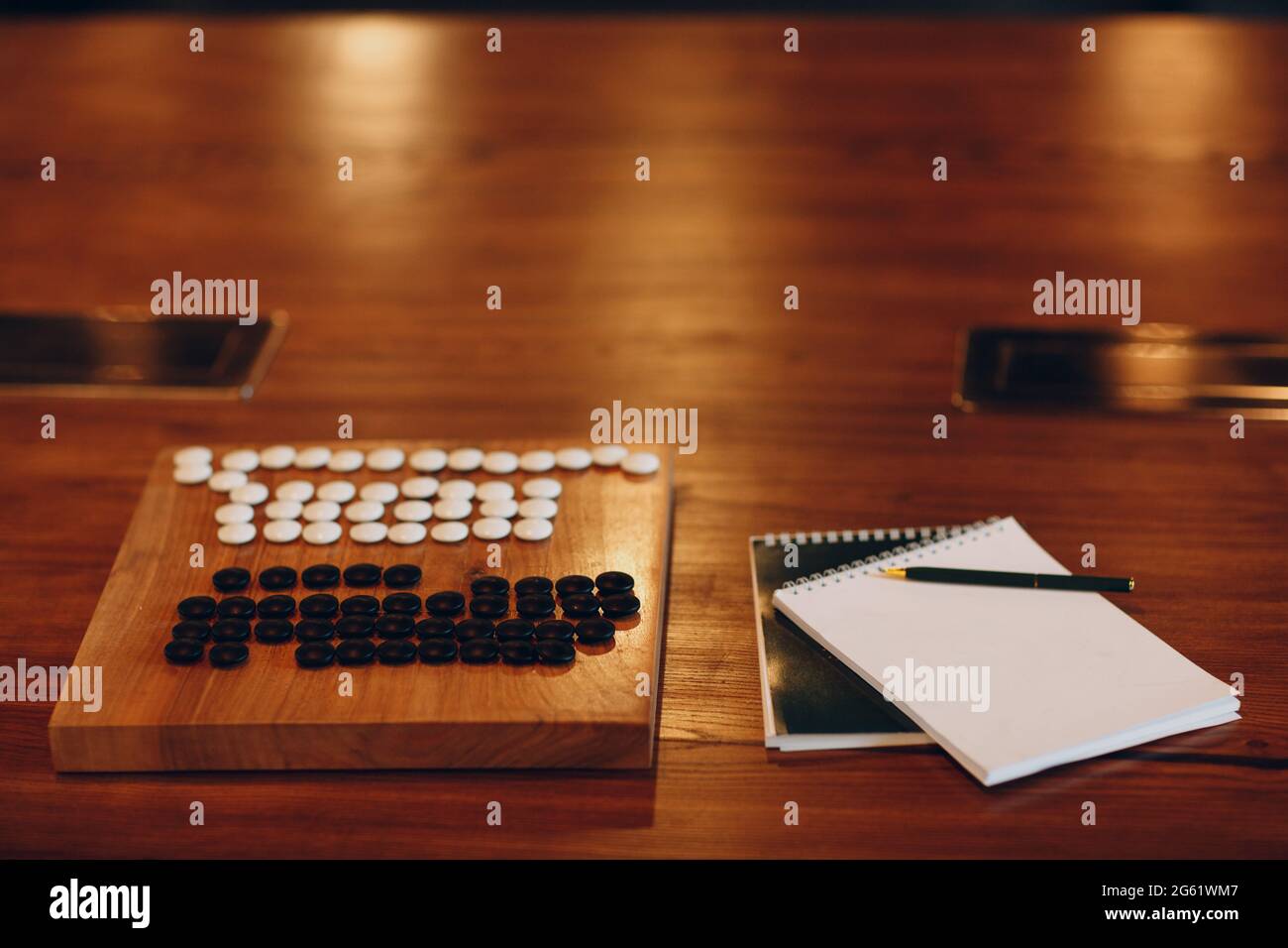 Weichi the game of go lies on the table with a blank white notebook and ...