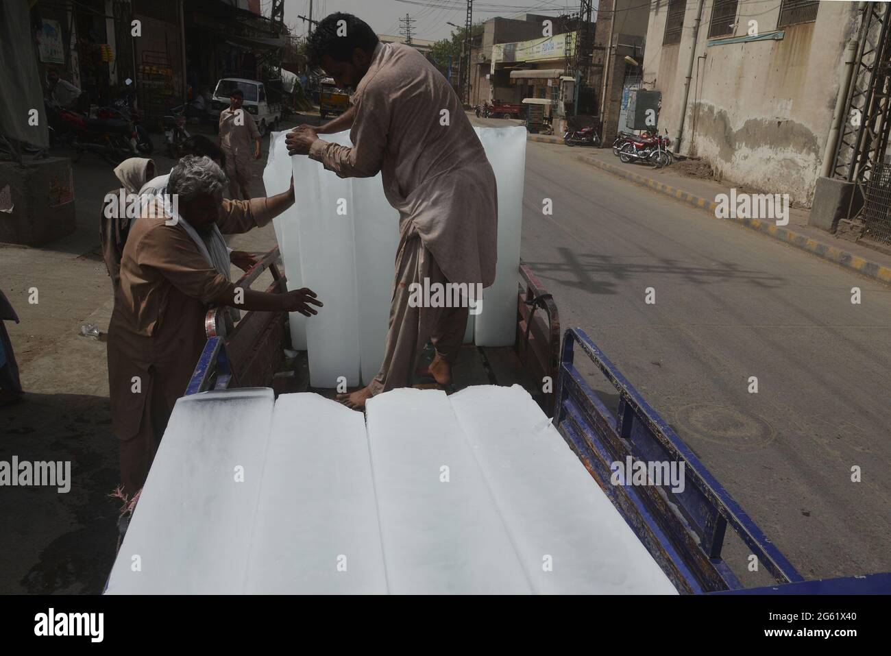 Lahore, Pakistan. 01st July, 2021. Pakistani vendors are loading ice ...