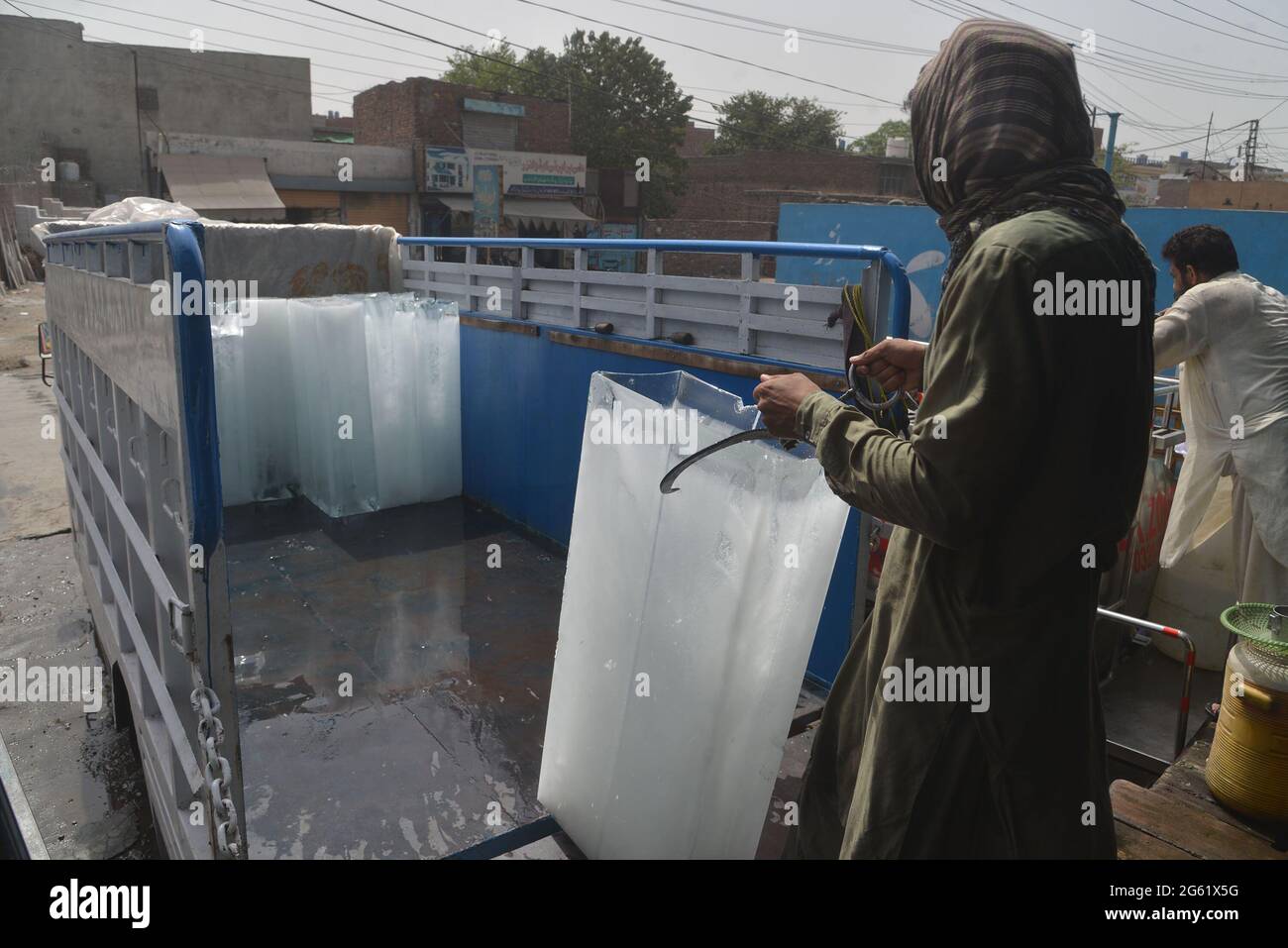 Lahore, Pakistan. 01st July, 2021. Pakistani vendors are loading ice ...