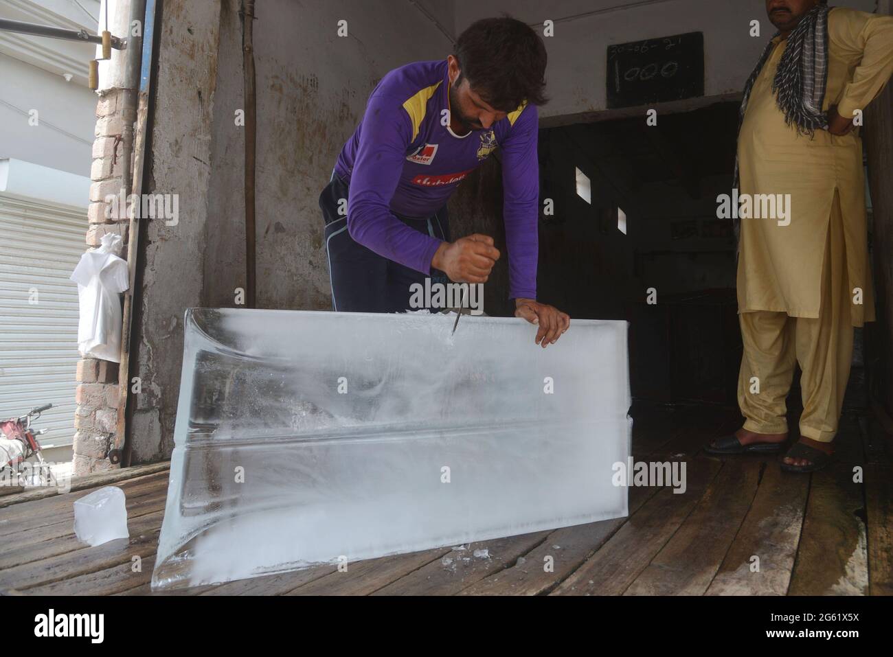 Lahore, Pakistan. 01st July, 2021. Pakistani vendors are loading ice ...