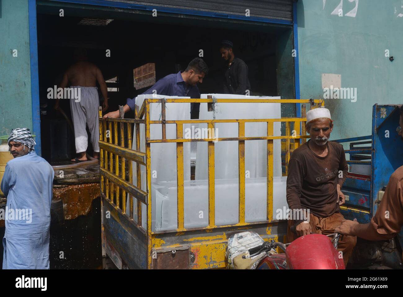 Lahore, Pakistan. 01st July, 2021. Pakistani vendors are loading ice ...