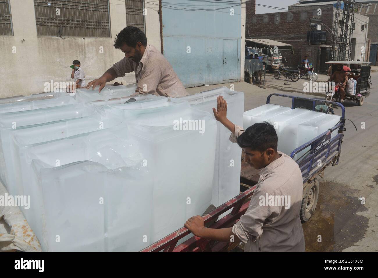 Lahore, Pakistan. 01st July, 2021. Pakistani vendors are loading ice ...