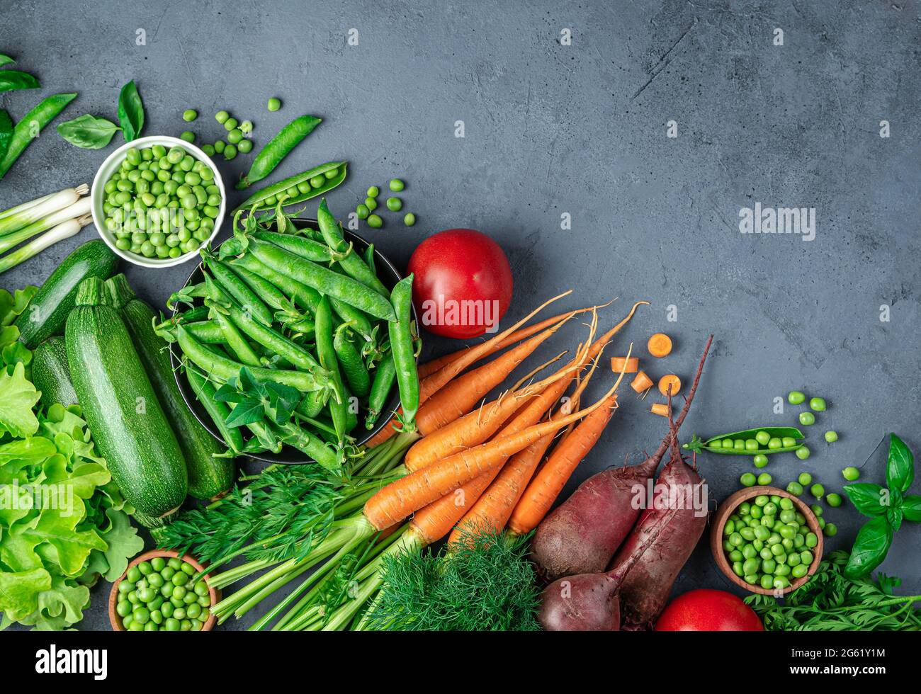 A set of fresh, young vegetables on a dark blue background. Top view ...
