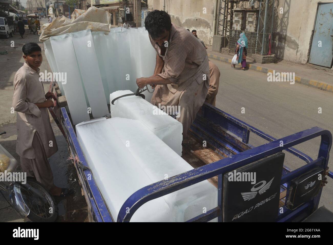 Lahore, Pakistan. 01st July, 2021. Pakistani vendors are loading ice ...