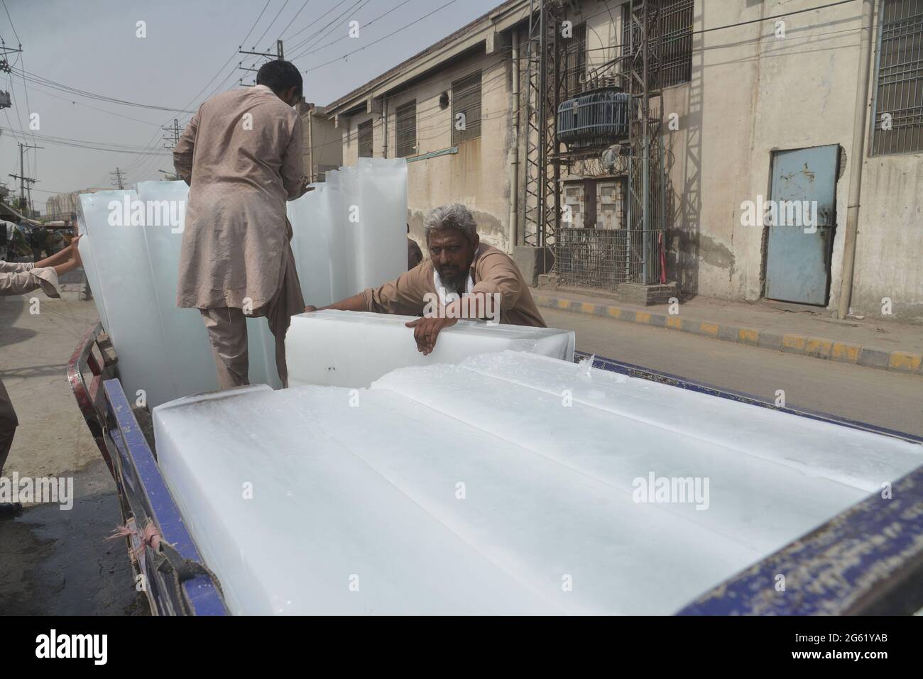 Lahore, Pakistan. 01st July, 2021. Pakistani vendors are loading ice ...