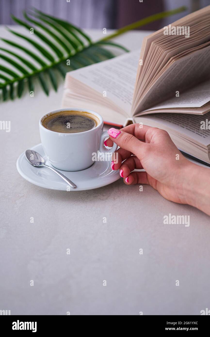 Delicious, aromatic morning coffee and reading a book in a coffee shop ...