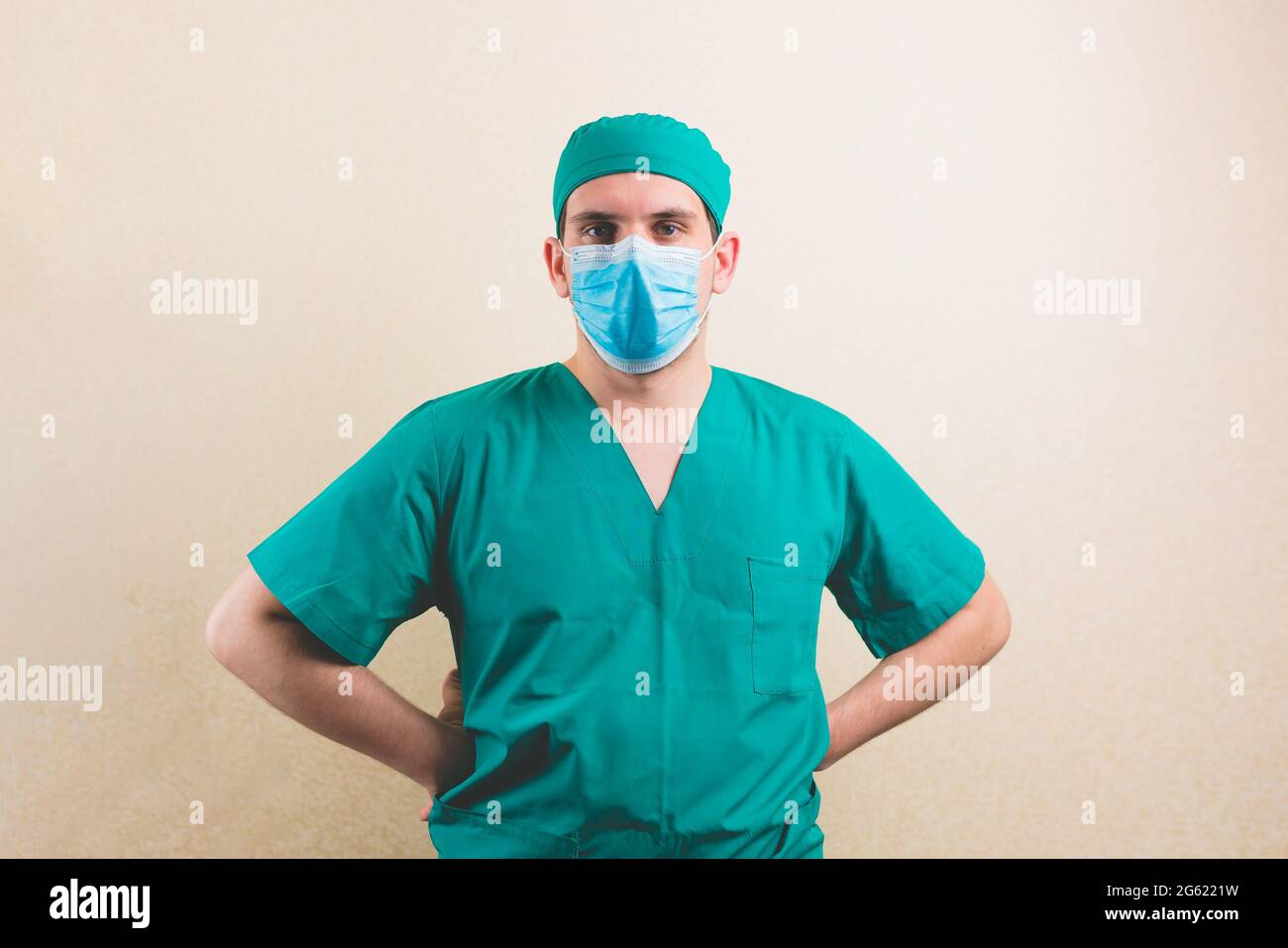 Doctor in green surgeon suitand protective breathing mask looking ...