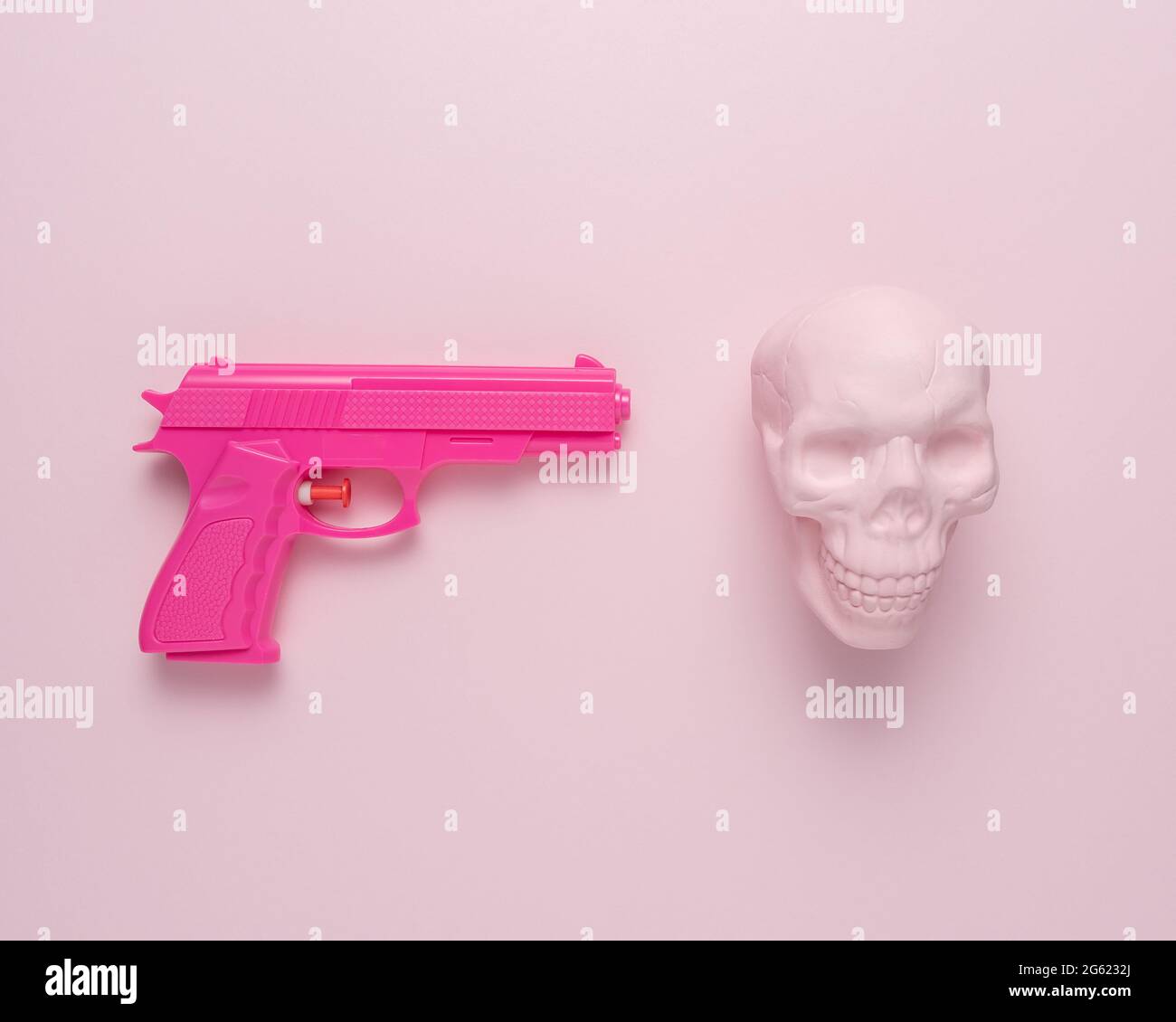 Pink handgun on pink pastel background with pink skull. Minimal ...