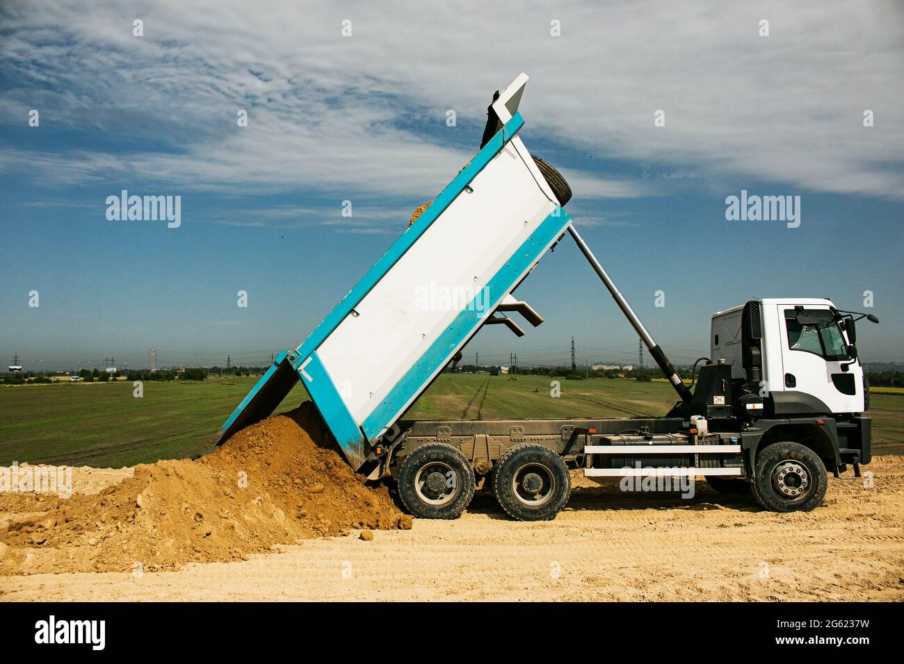 Dump truck unloads clay soil for the construction of a new highway ...