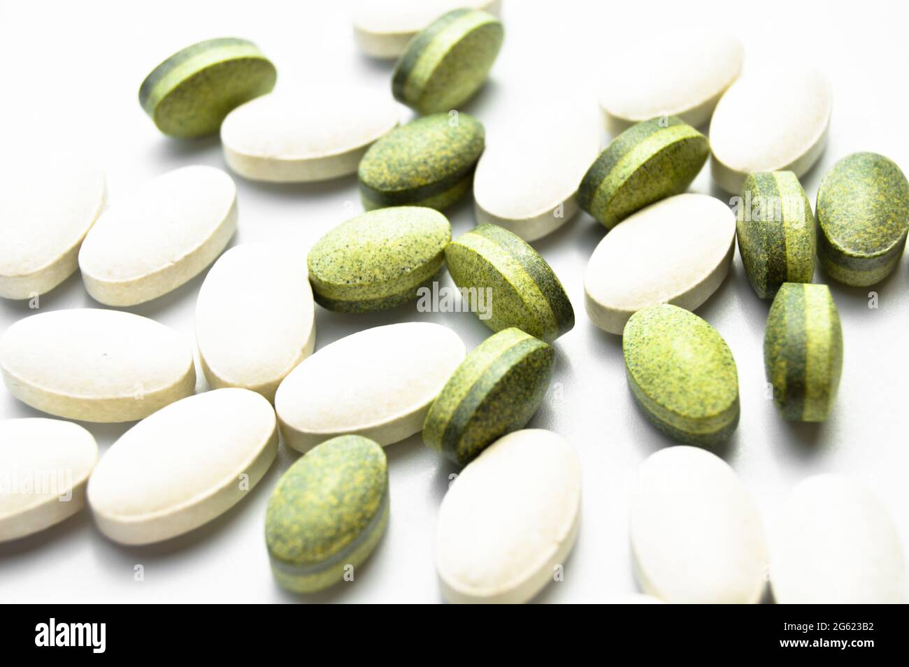 White and green oval tablet pills isolated on white background, medical ...