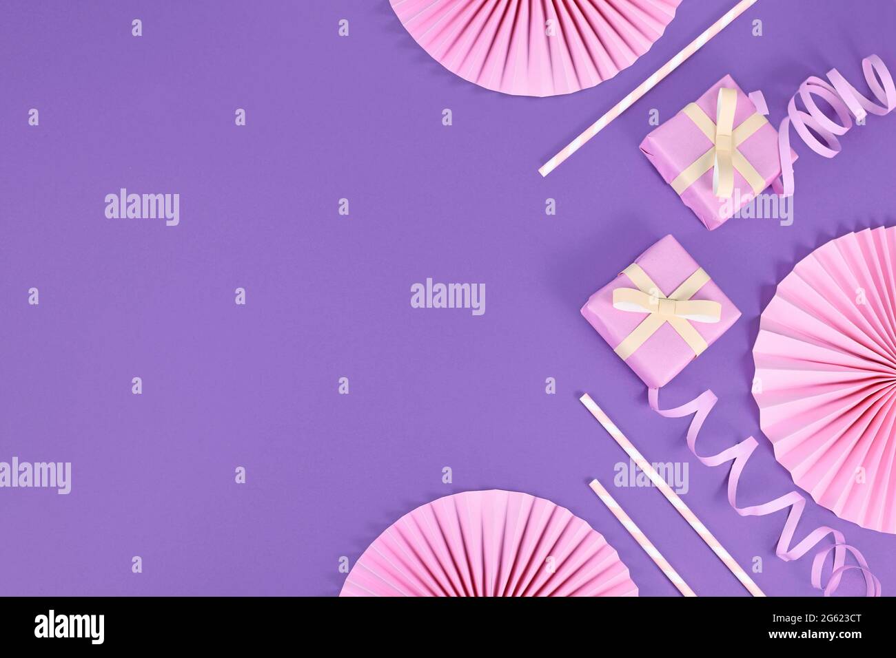 Violet party flat lay with pink gift boxes, paper streamers, drinking ...