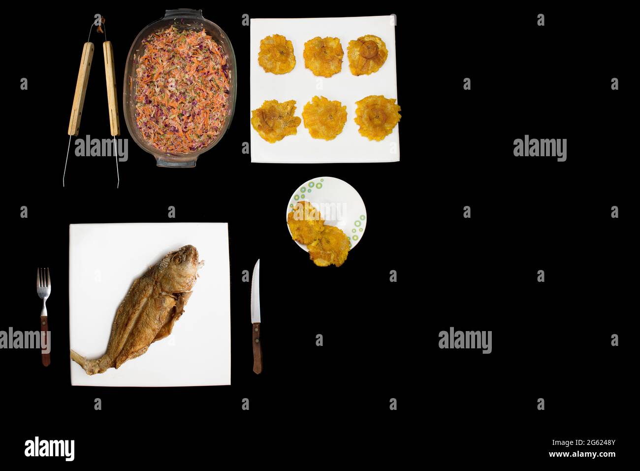 Fried fish with tostones and grated carrot salad, cabbage, lettuce ...
