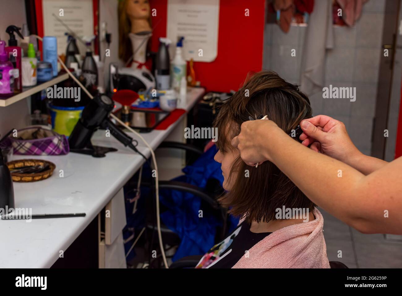 Professional female hairdresser cutting girl's hair in salon Stock ...