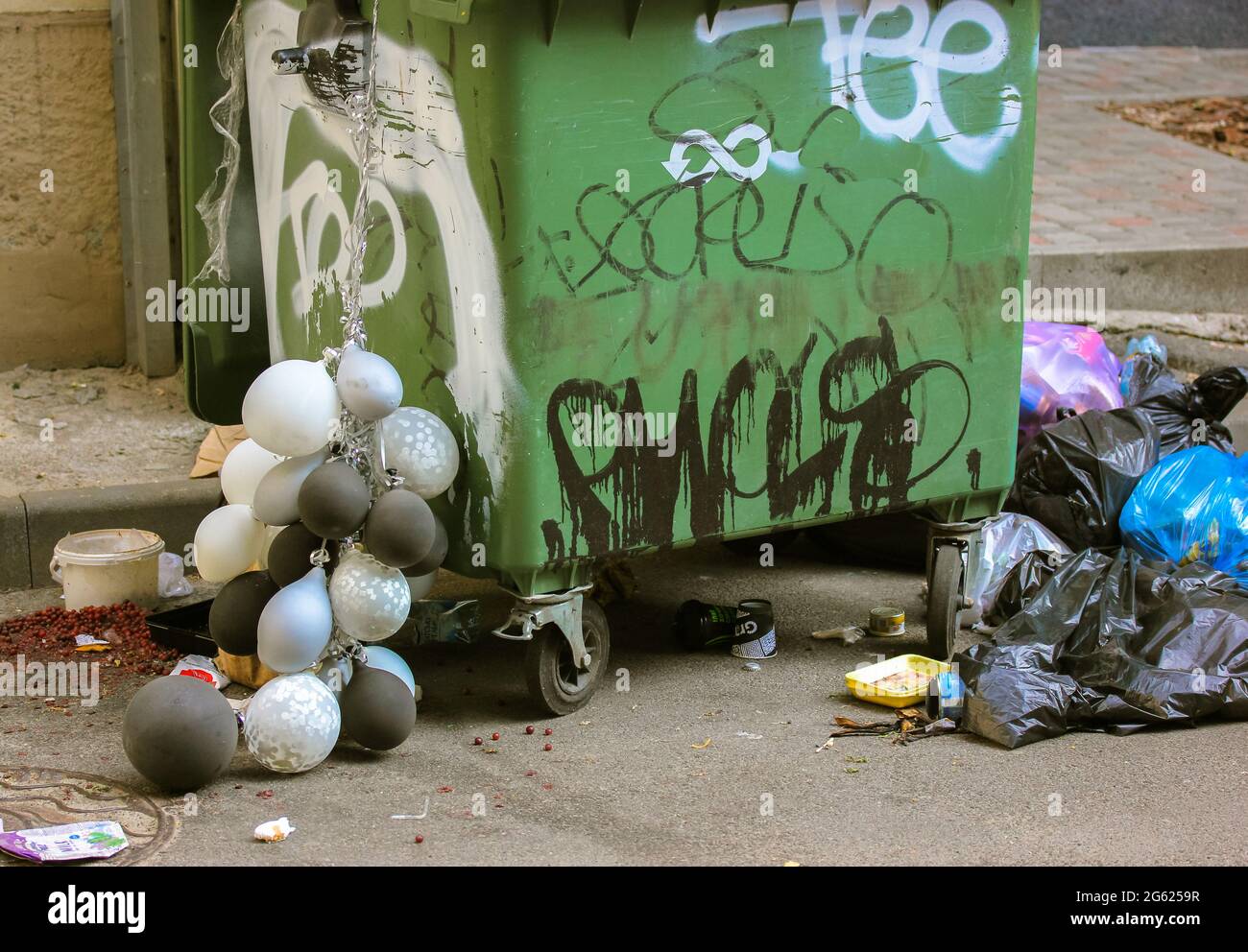 Green metal dirty can, dumpster full of trash, garbage. Trash bags ...