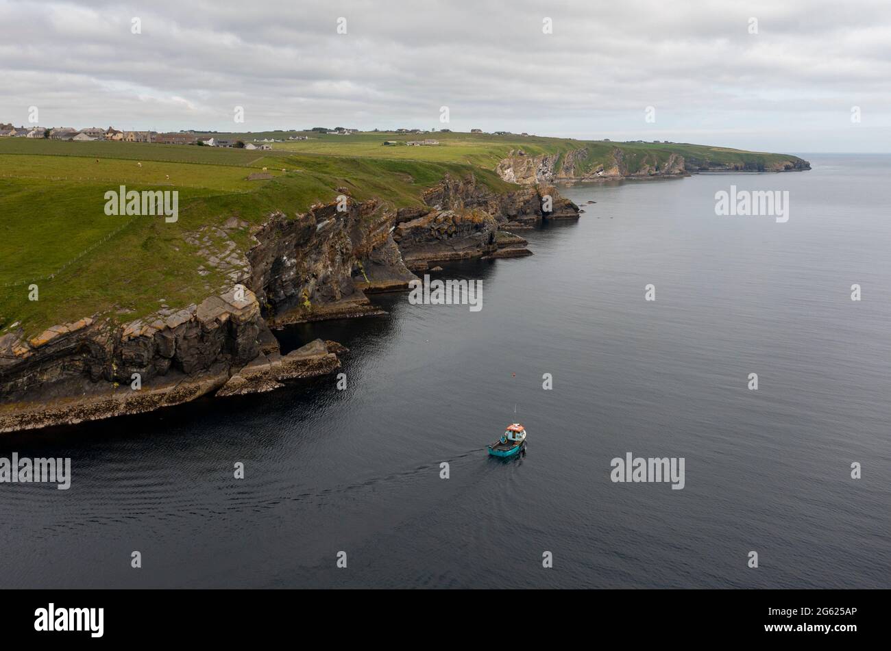 Aerial view of fishing boat leaving Lybster Harbour, Caithness ...