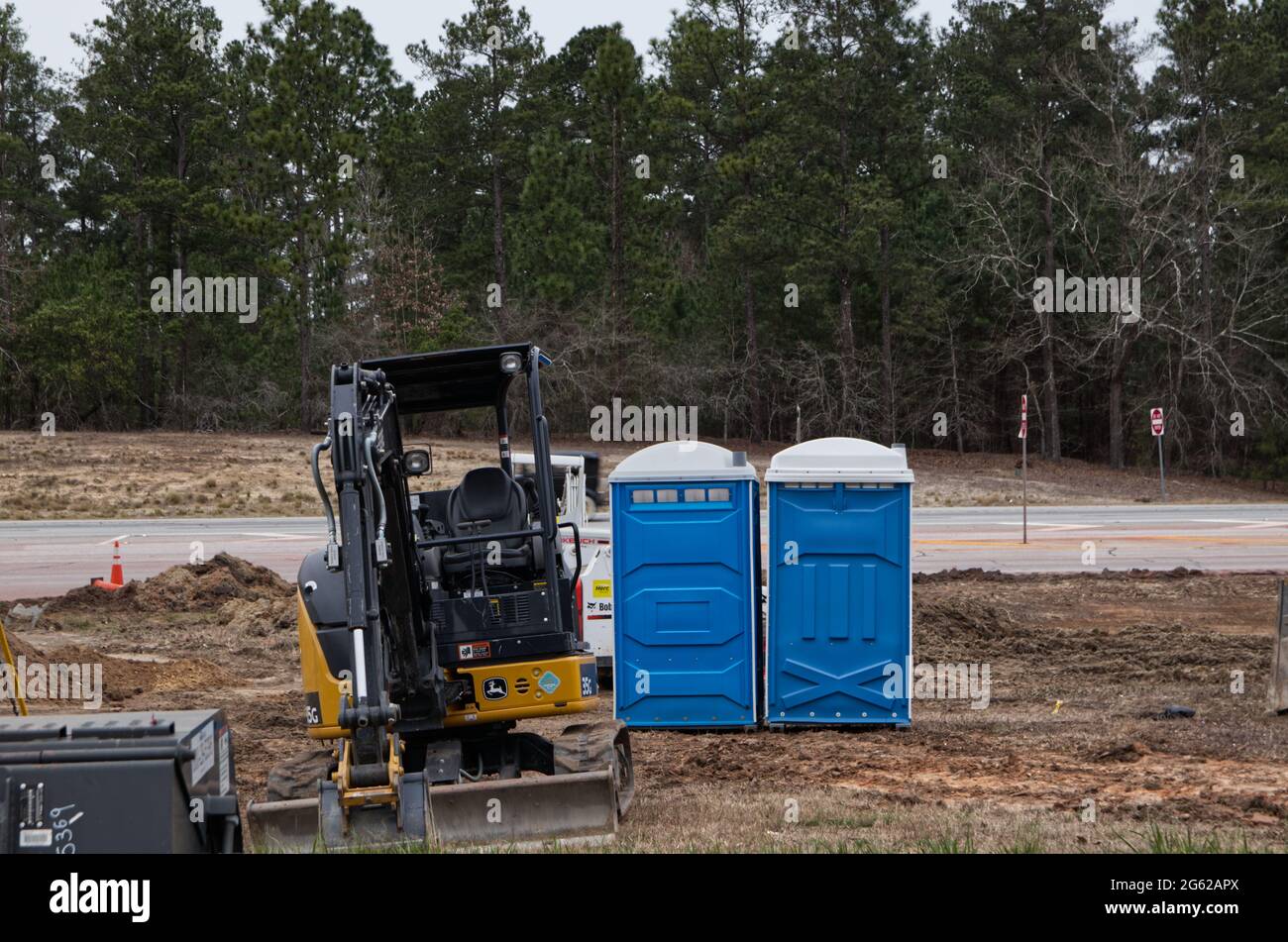 Augusta, Ga USA - 03 06 21: Blue portable bathrooms and a ditch digger ...