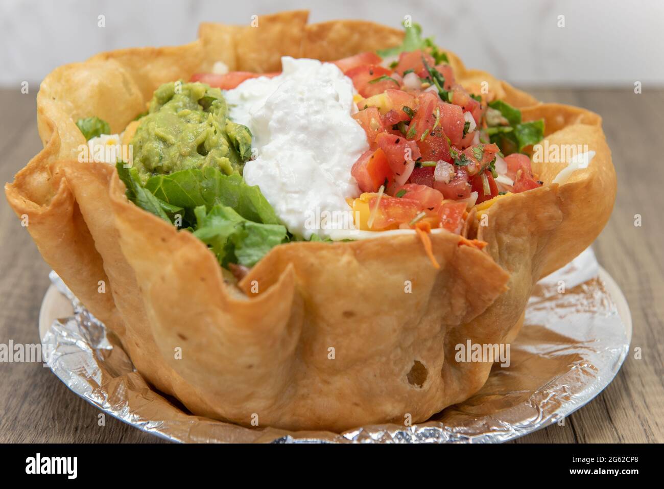 Huge tostada crispy bowl filled completely and topped with scoops of ...